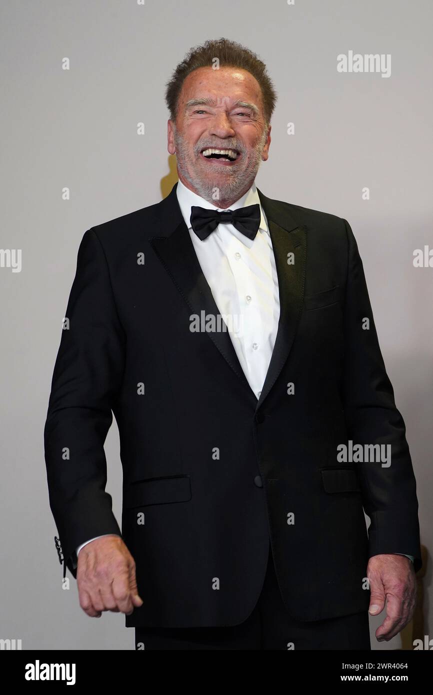 Arnold Schwarzenegger poses in the press room at the Oscars on Sunday ...