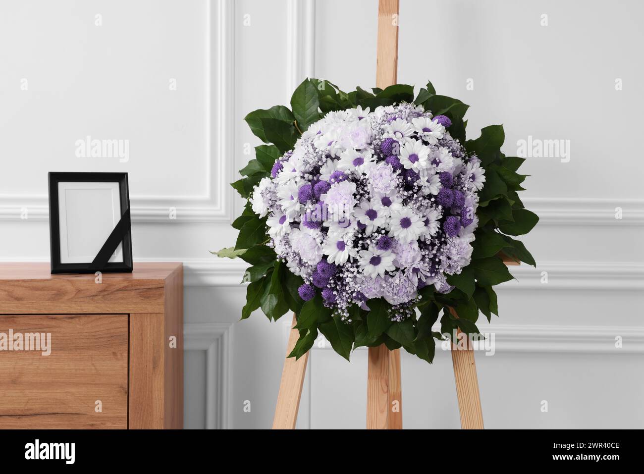 Wreath of violet and white flowers, photo frame with black ribbon in ...