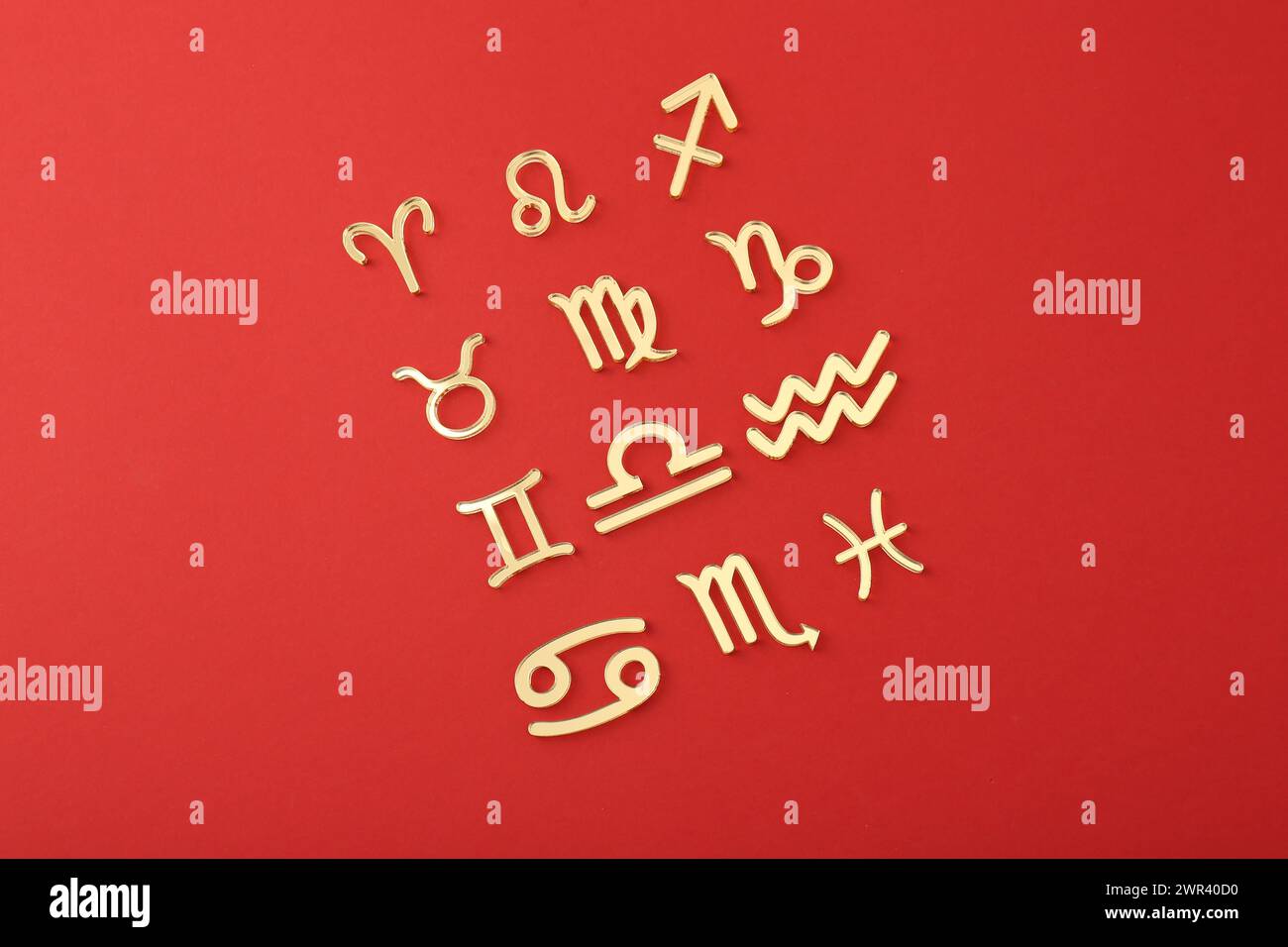 Zodiac signs on red background, flat lay Stock Photo - Alamy