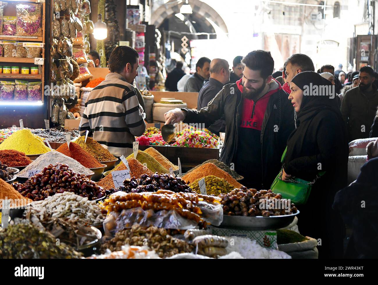 Damascus, Syria. 10th Mar, 2024. People buy dates and dried fruits ...