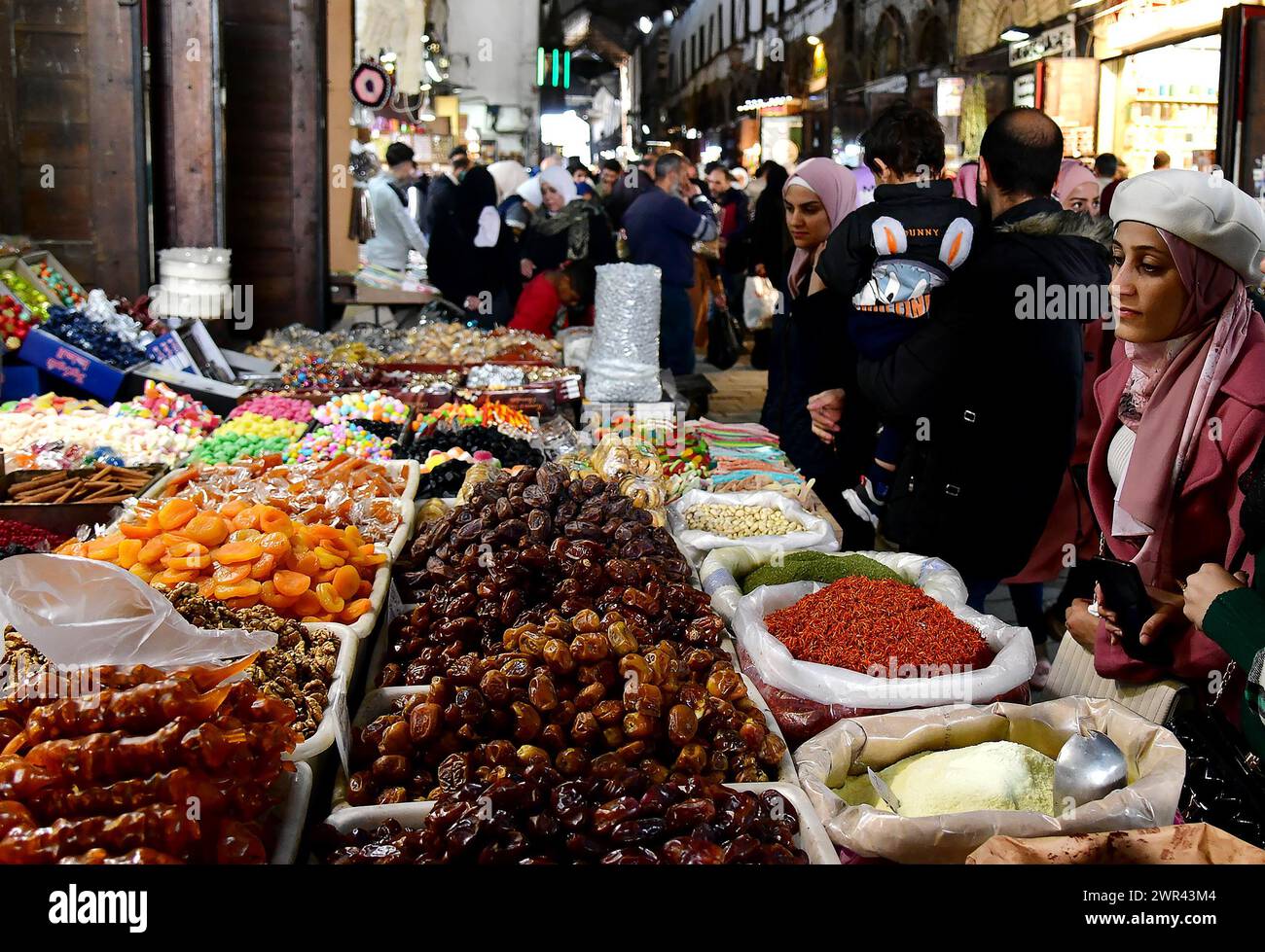 Damascus, Syria. 10th Mar, 2024. People buy dates and dried fruits ...