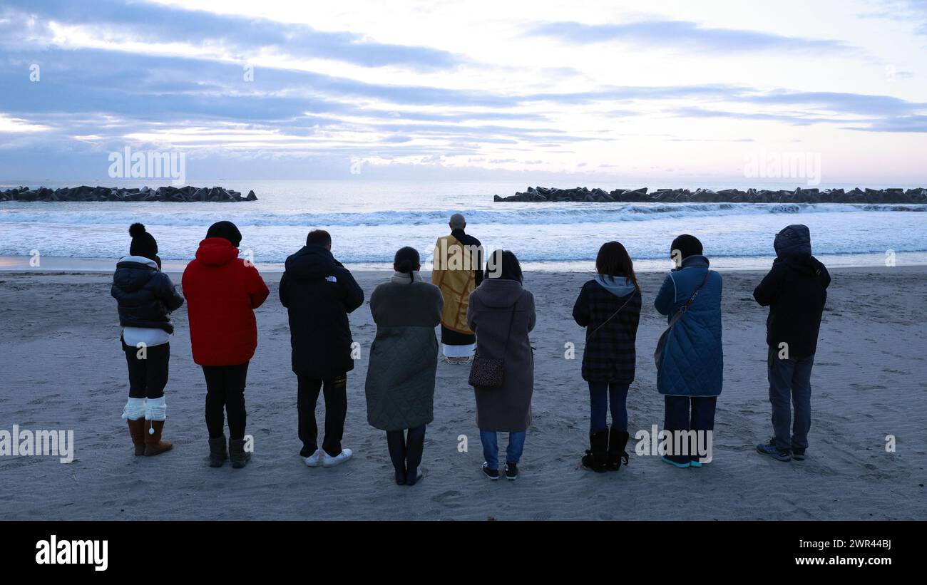 People pray on a beach in Sendai, Miyagi Prefecture, northeastern Japan ...
