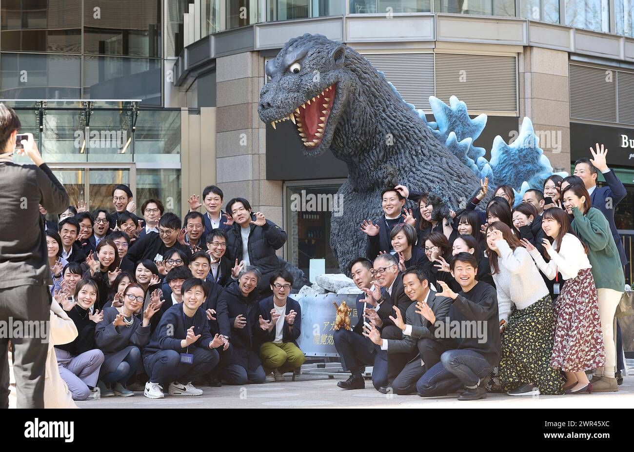 People take a photo with the Godzilla statue t in Chiyoda Ward, Tokyo ...