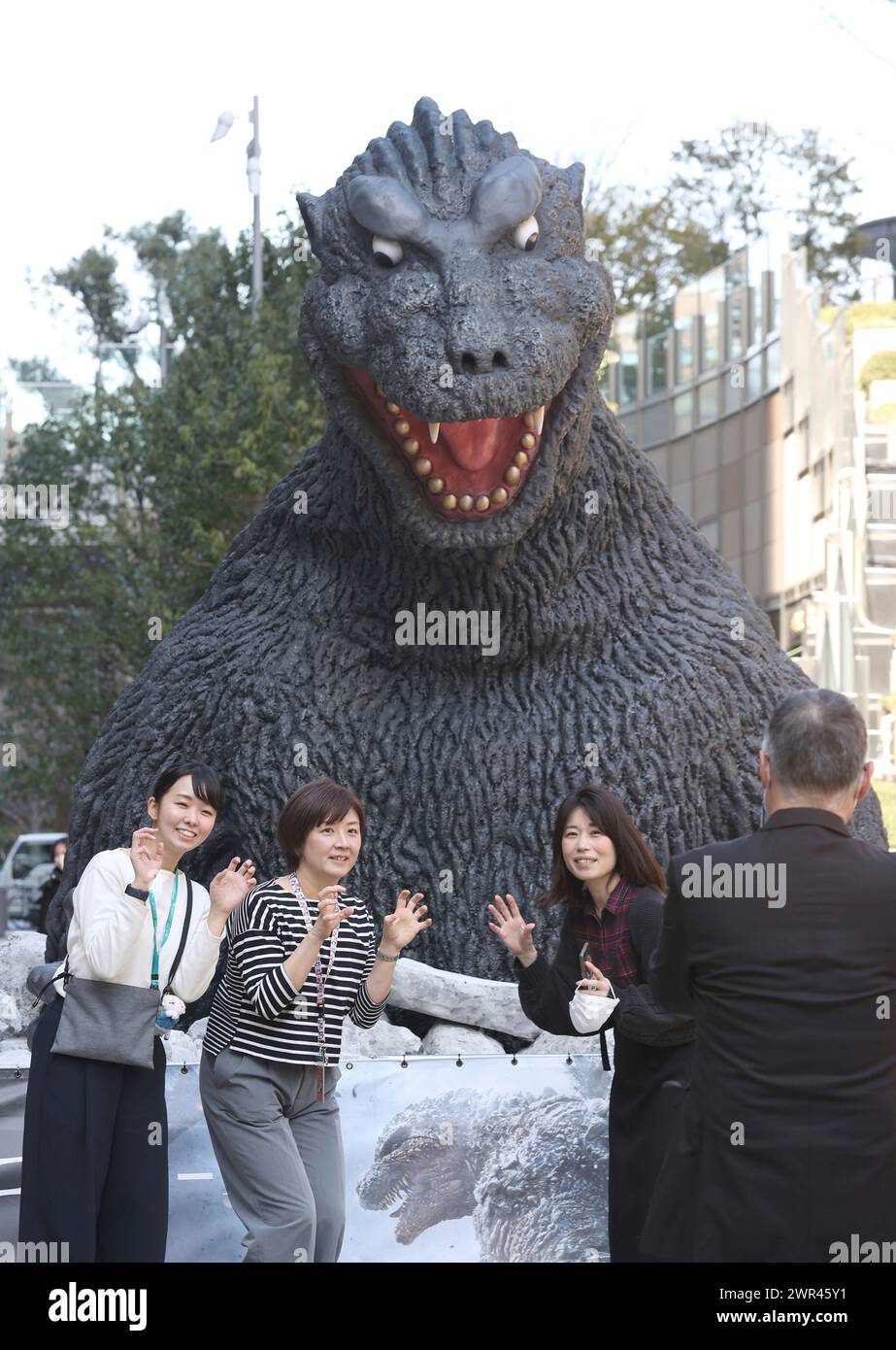 People take a photo with the Godzilla statue t in Chiyoda Ward, Tokyo ...