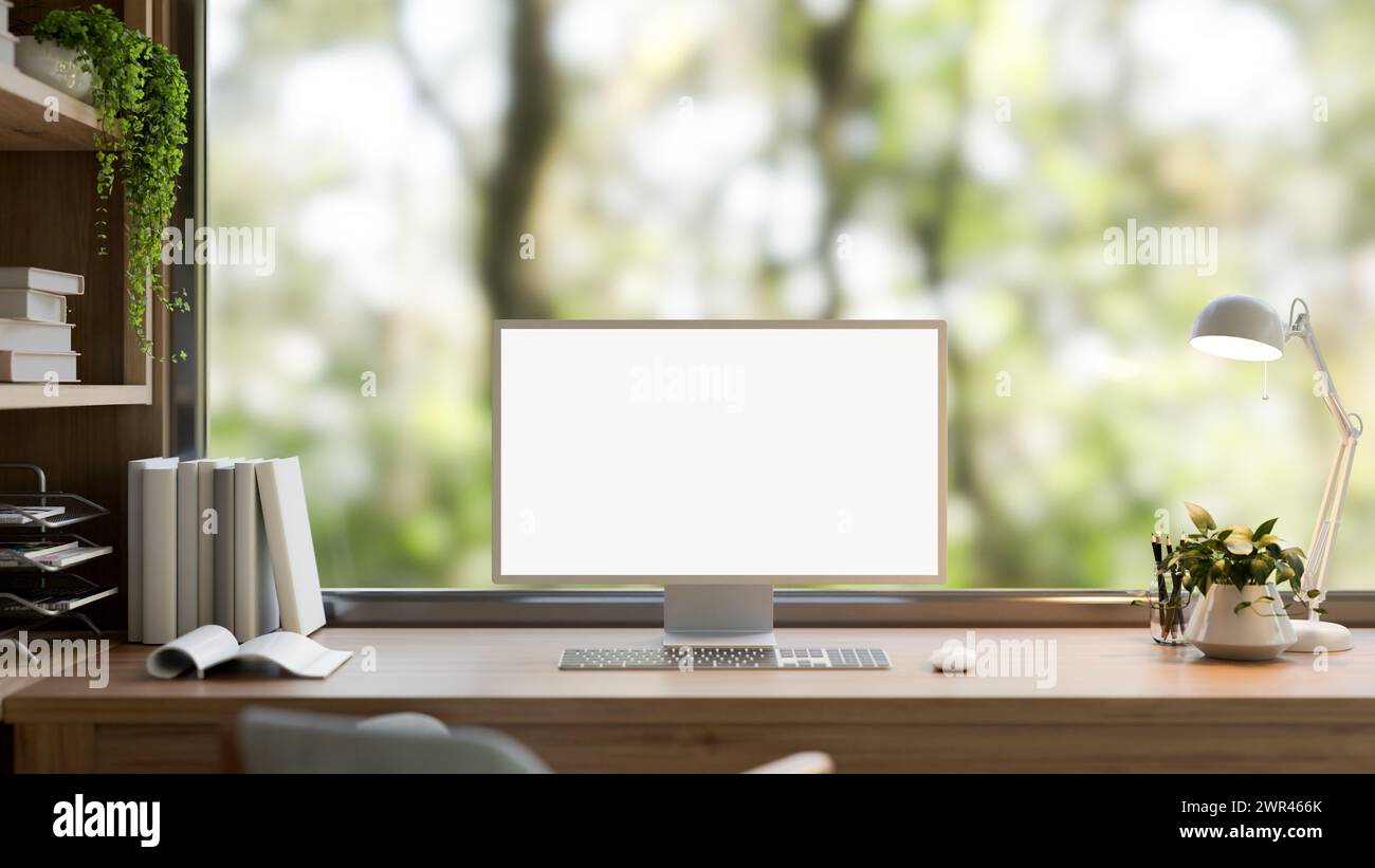 A computer white-screen mockup on a wooden desk against the window in a ...