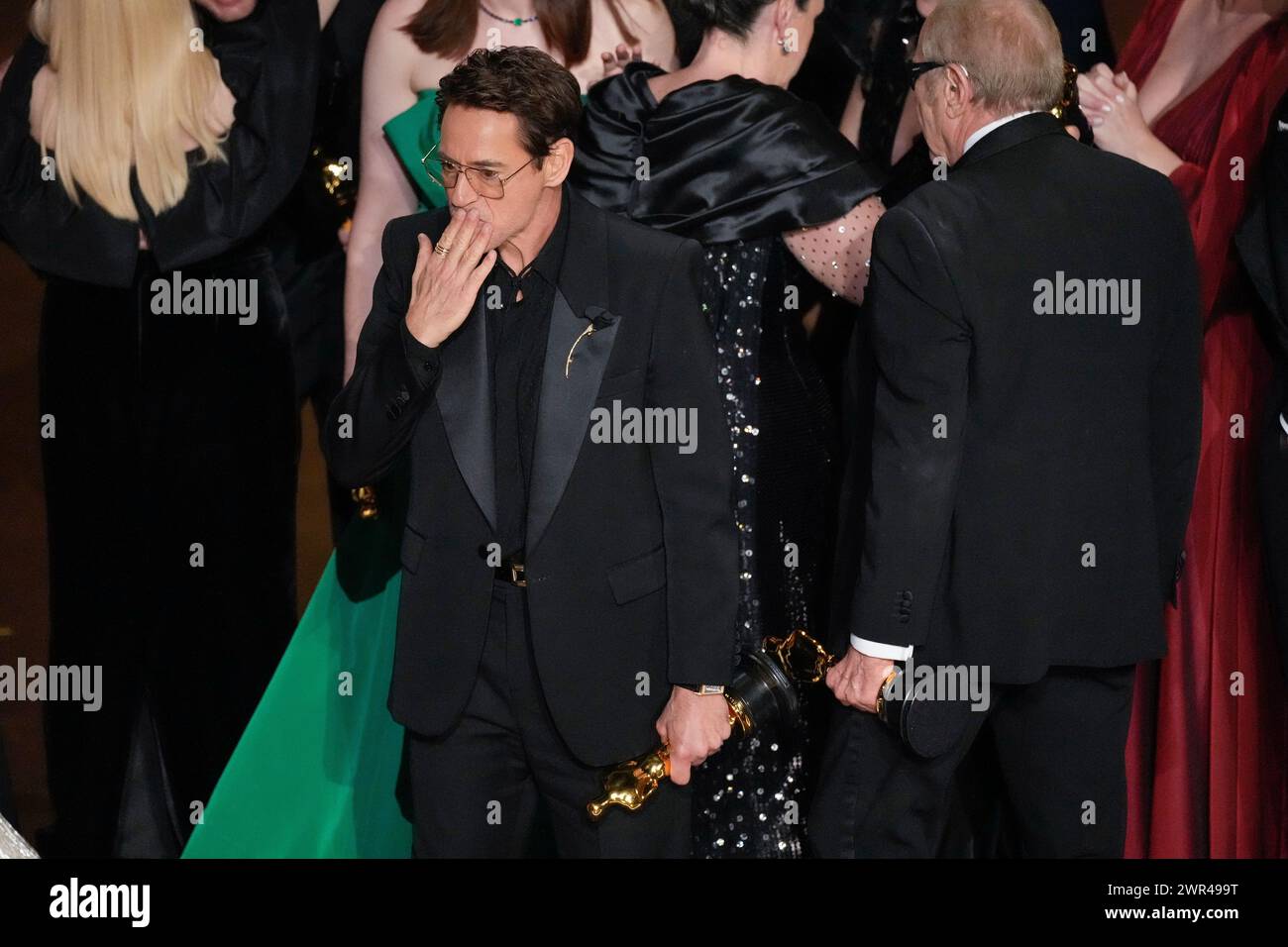 Robert Downey Jr. reacts as the cast and crew of "Oppenheimer" accept the award for best picture ...