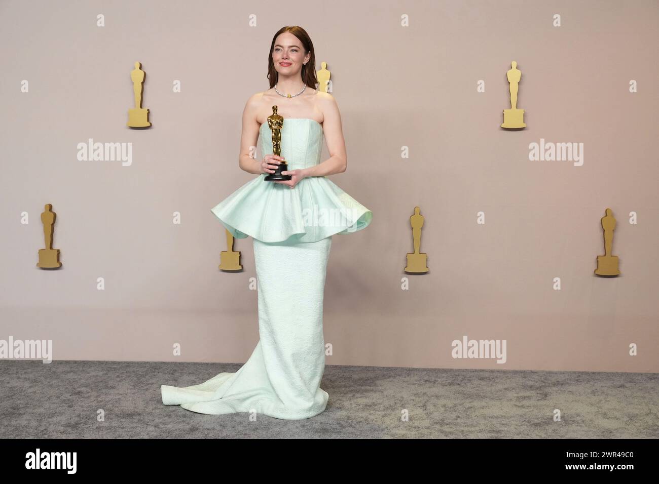 Emma Stone poses in the press room with the award for best performance ...