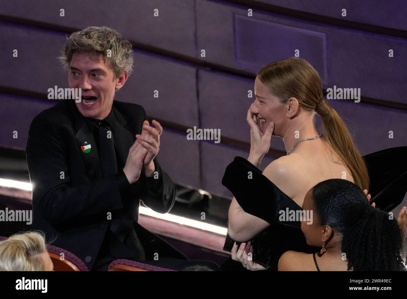 Swann Arlaud, left, and Sandra Huller applaud as Arthur Harari and Justine Triet win the best ...
