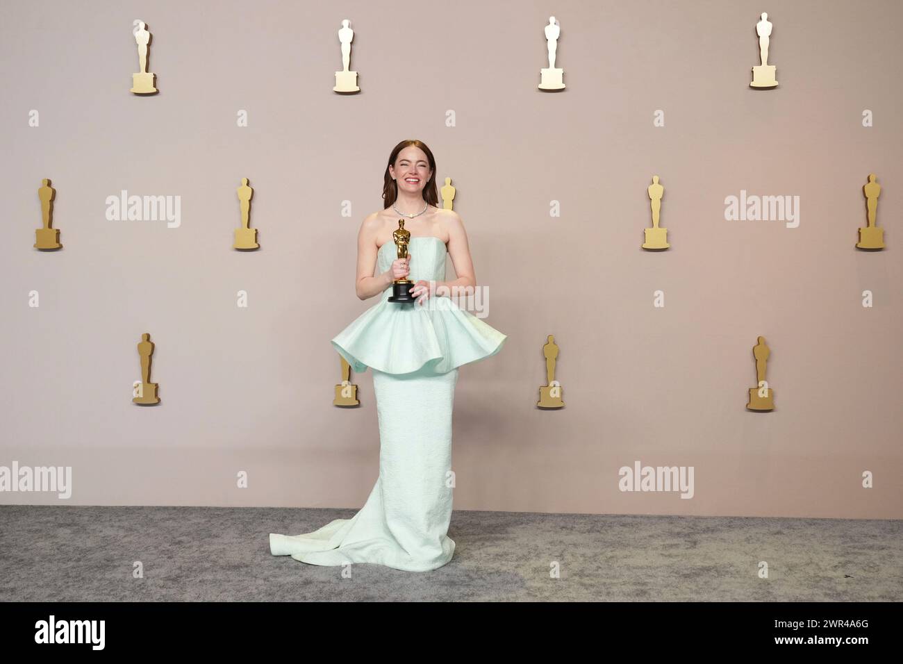 Emma Stone poses in the press room with the award for best performance ...