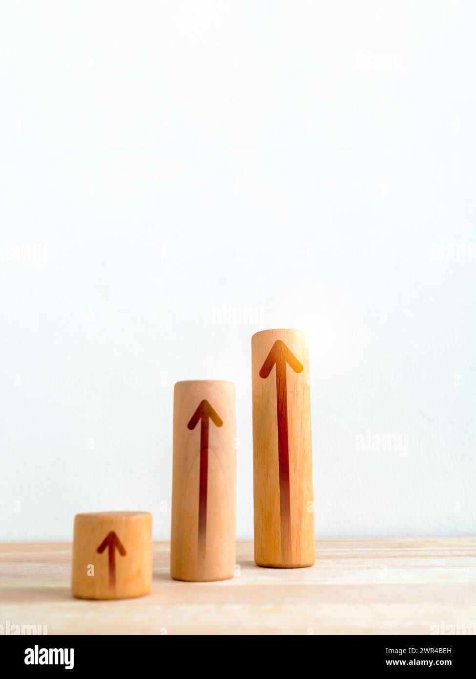 Rising up arrows on round wooden sticks as business graph steps ...