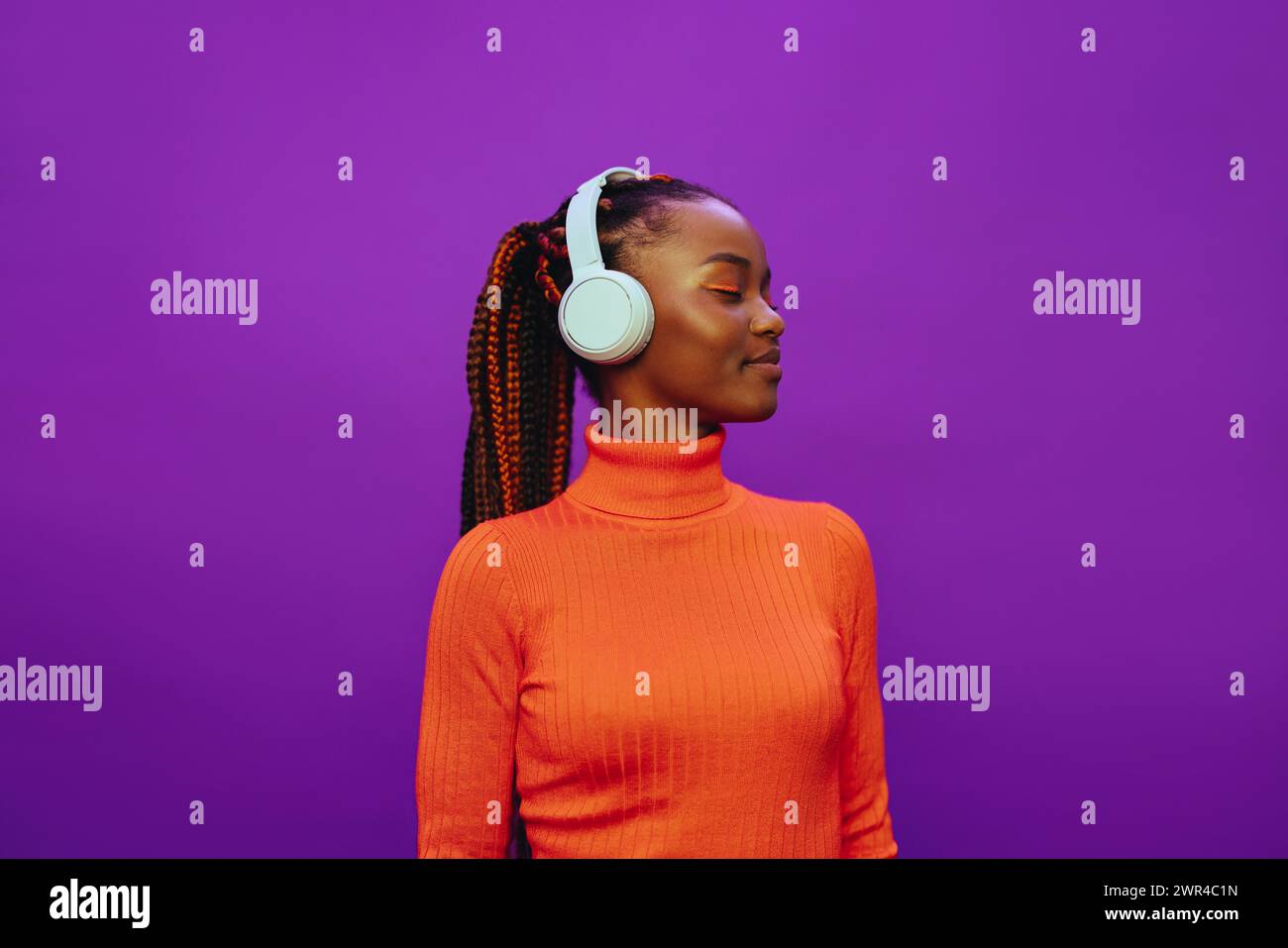 African woman stands in a studio, wearing casual clothing and a polo ...