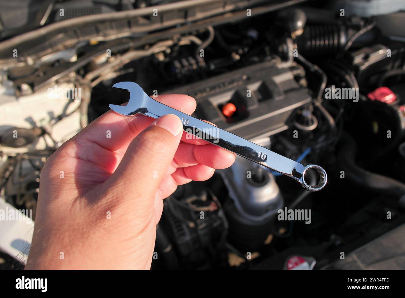 Combination wrench or open end spanner chrome in a car mechanic hand ...