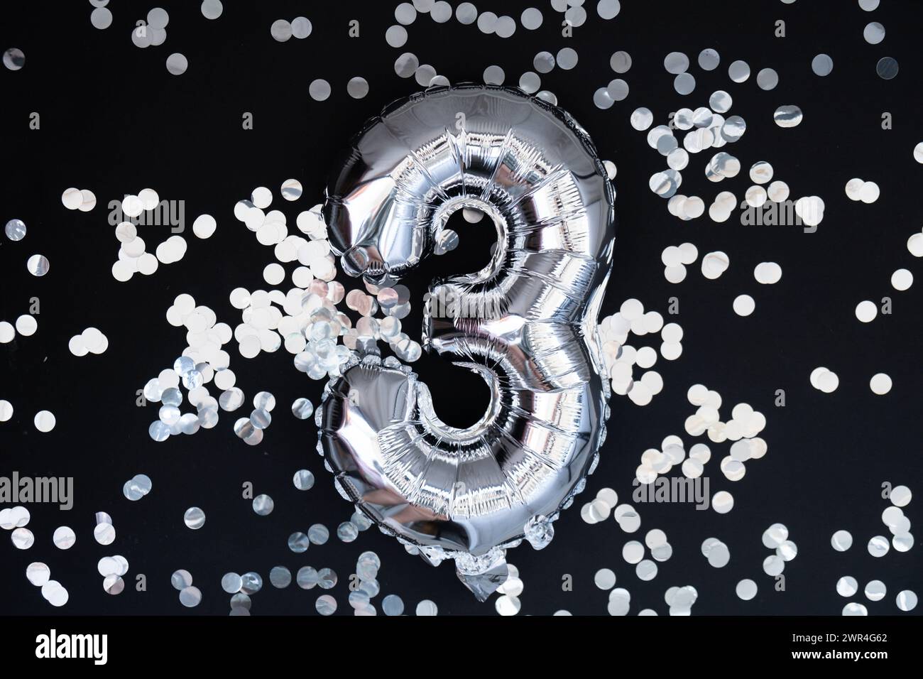 3 three metallic balloon with sparkling confetti on dark black ...