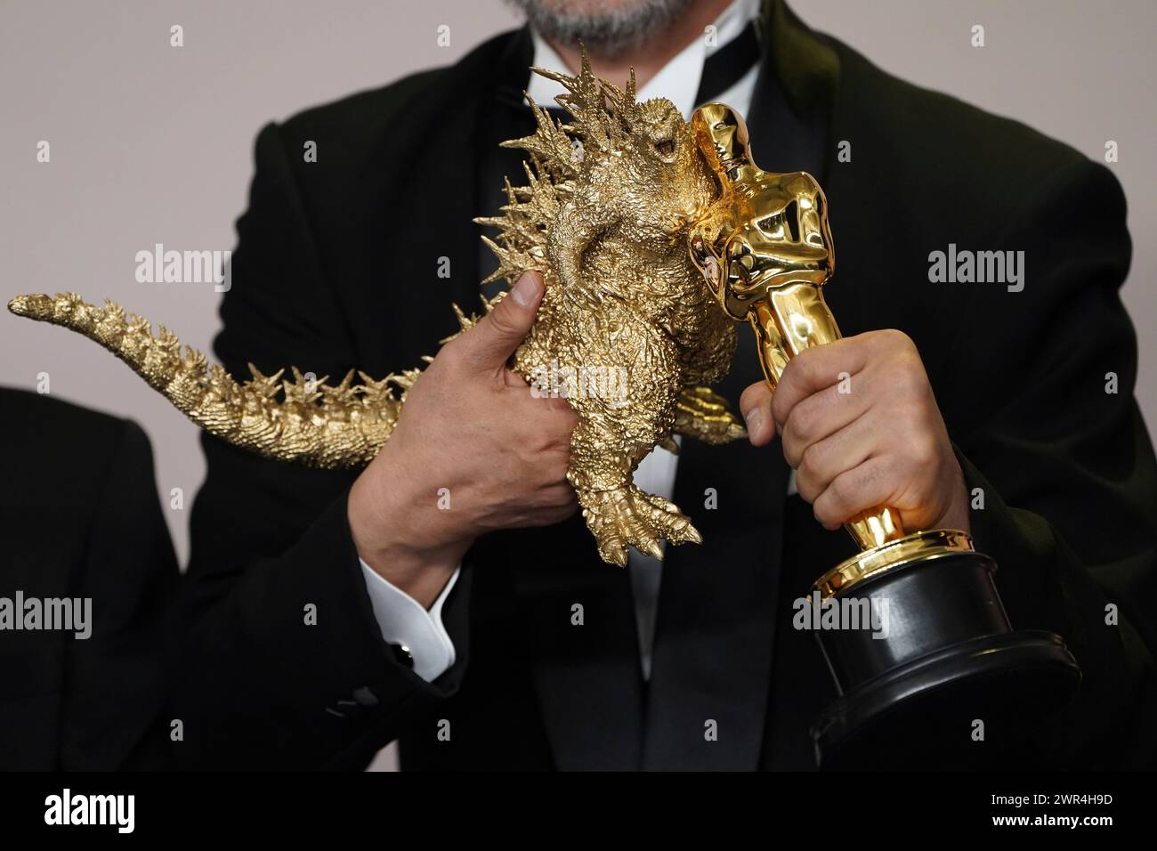 Takashi Yamazaki poses a Godzilla figurine with the award for best ...
