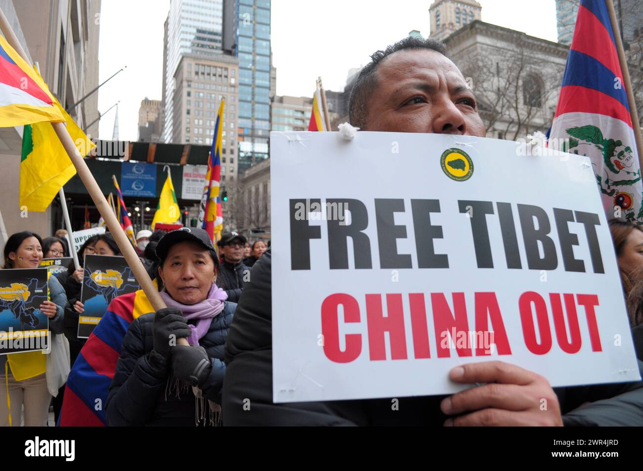 Pro-Tibet demonstrators march holding flags and placards expressing ...