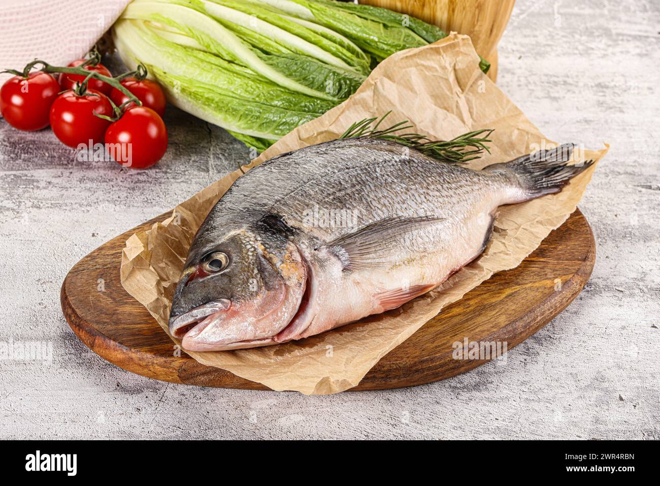 Raw dorada fish served rosemary for cooking Stock Photo - Alamy