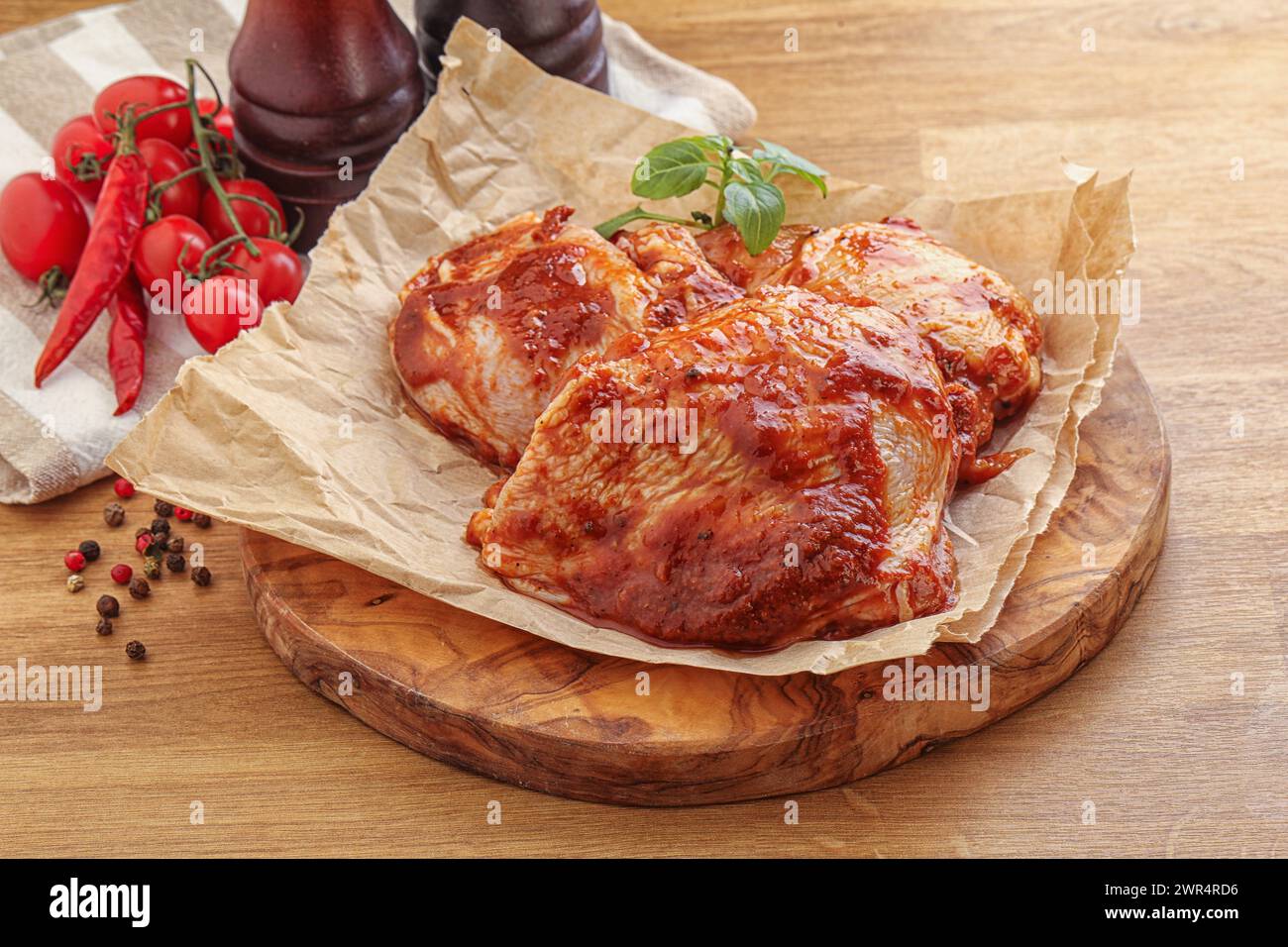 Marinated chicken leg thighs in tomato sauce Stock Photo - Alamy