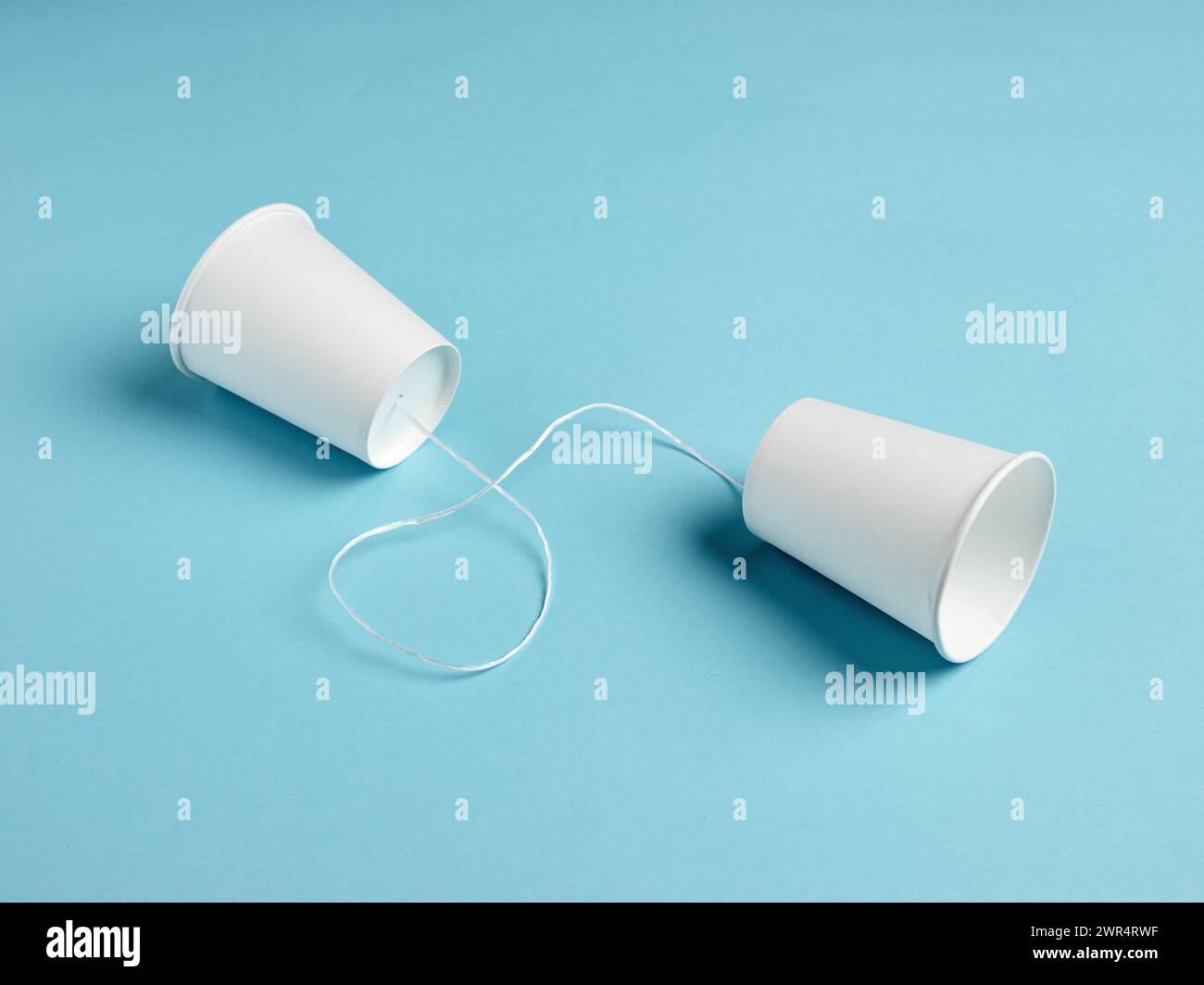 White paper cup phone on blue background. Communication and technology ...