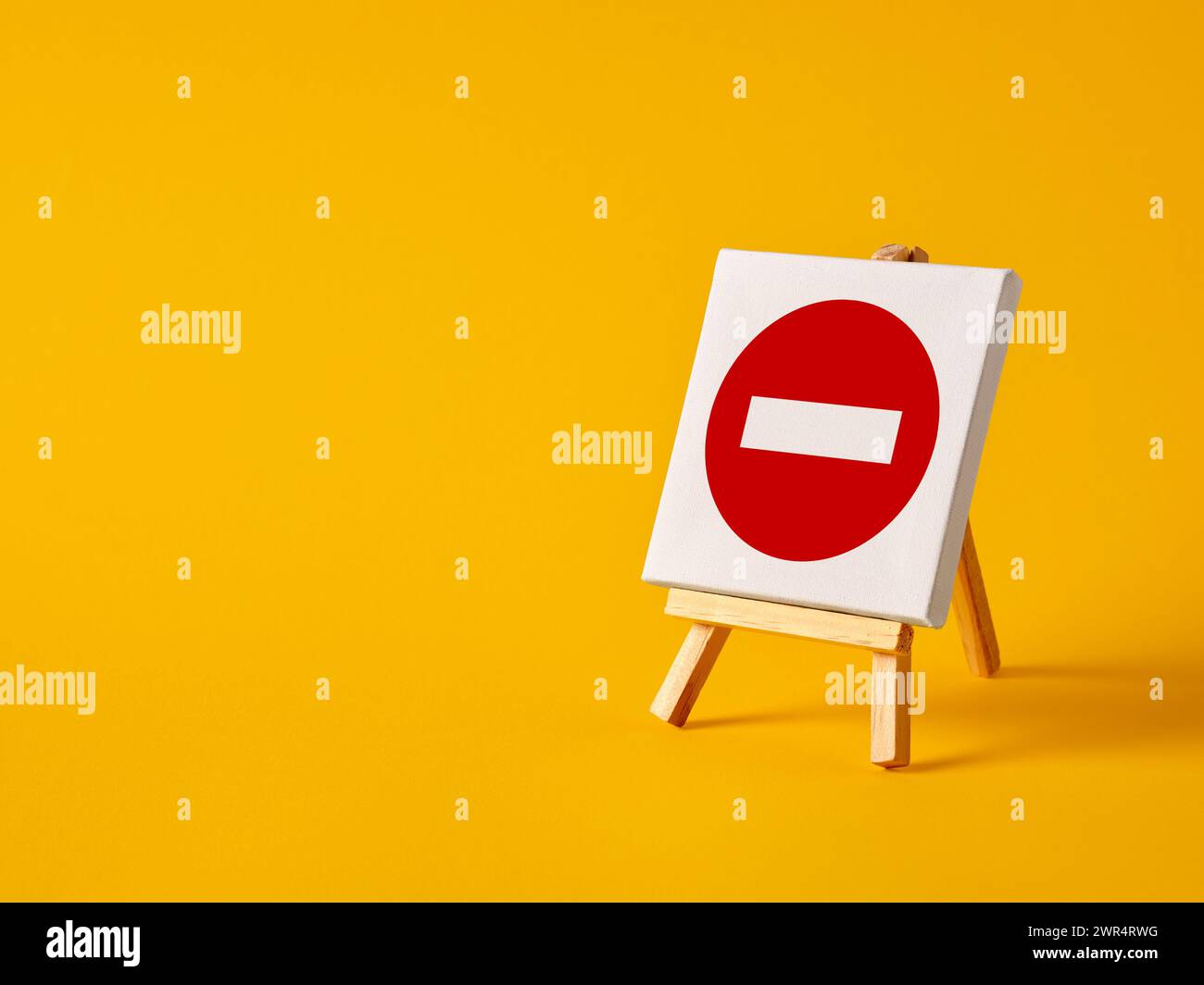 A canvas with no entry sign on an easel with yellow background with ...