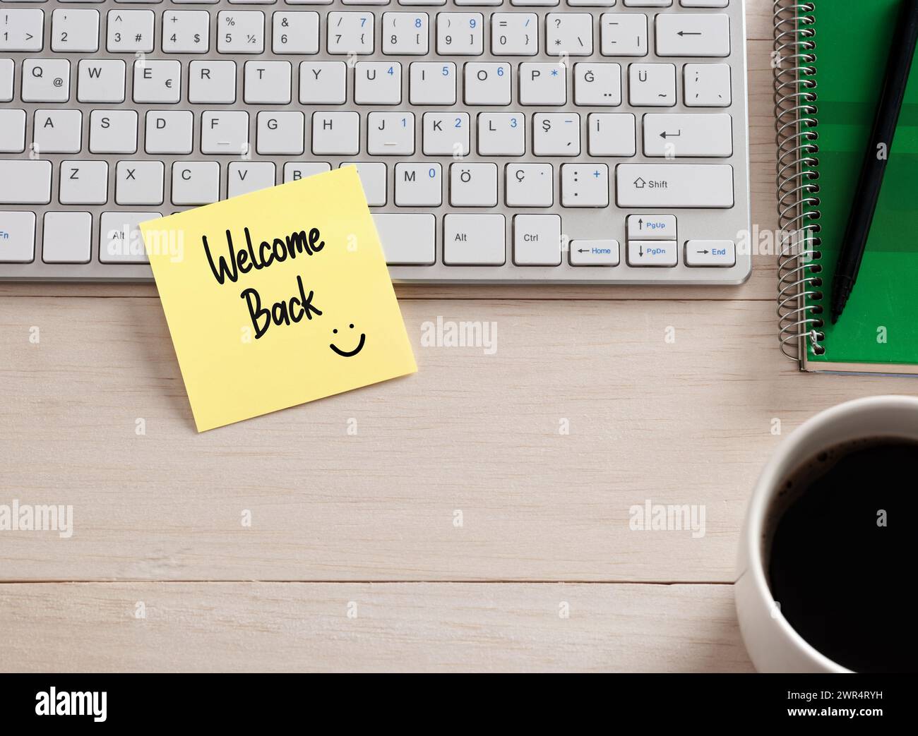 Welcome back message handwritten on a sticky note paper on the office ...