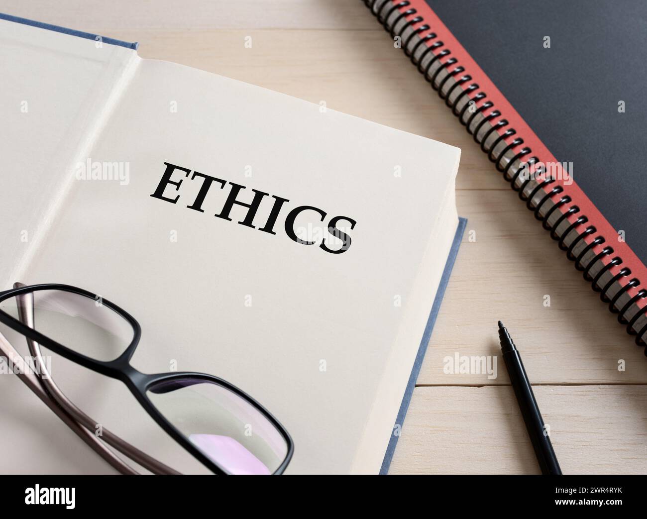 Ethics titled textbook on the office desk. Business ethics concept ...