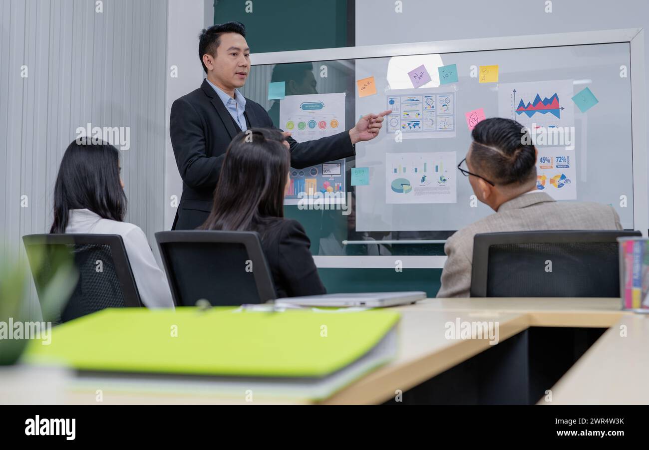 A man is giving a presentation to a group of people in a conference ...