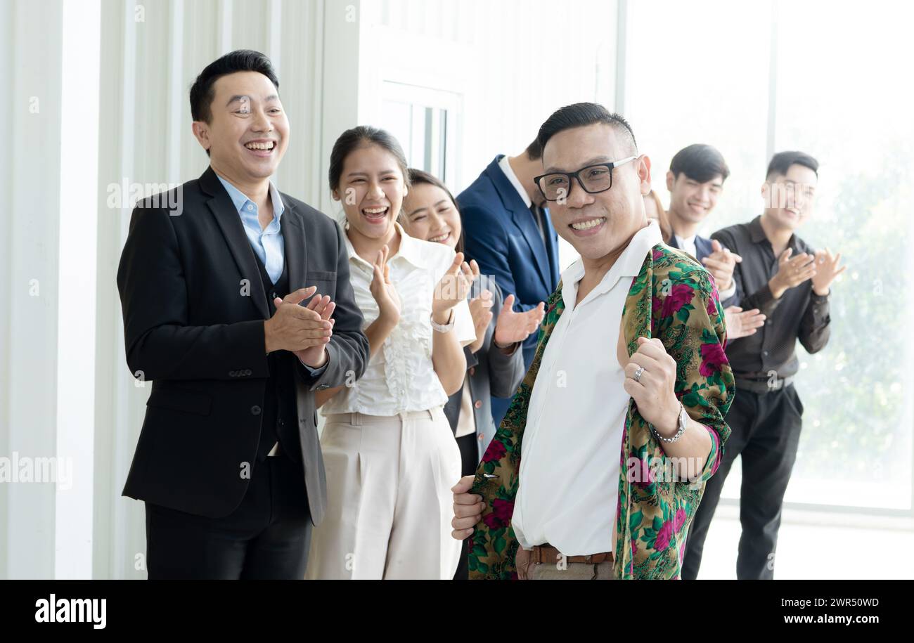A group of people are smiling and clapping, with one man in a floral ...