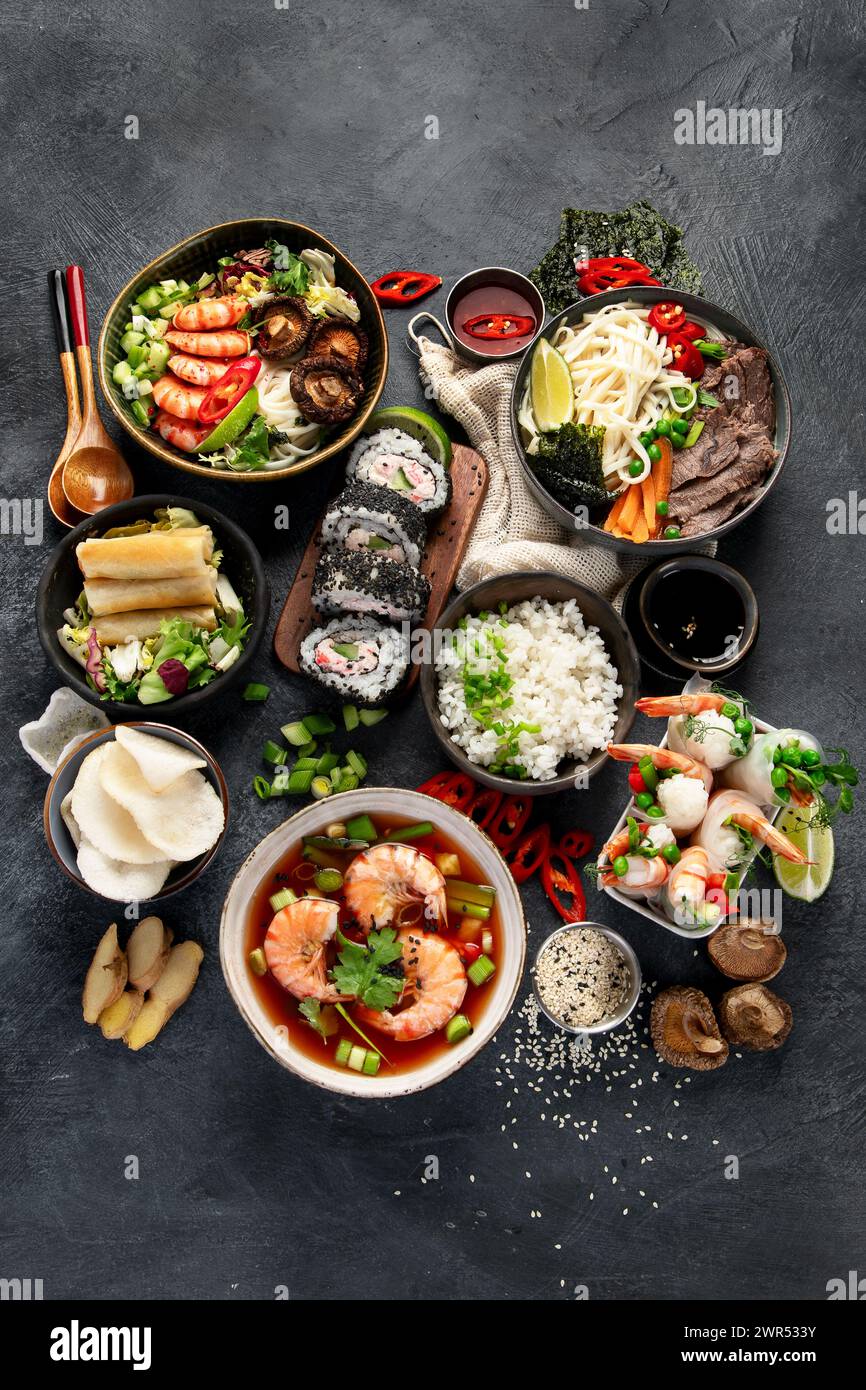 Traditional Asian food table. Spring roll, rice, shrimp, sushi ...