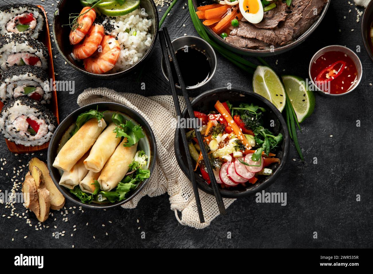 Traditional Asian food table. Spring roll, rice, shrimp, sushi ...