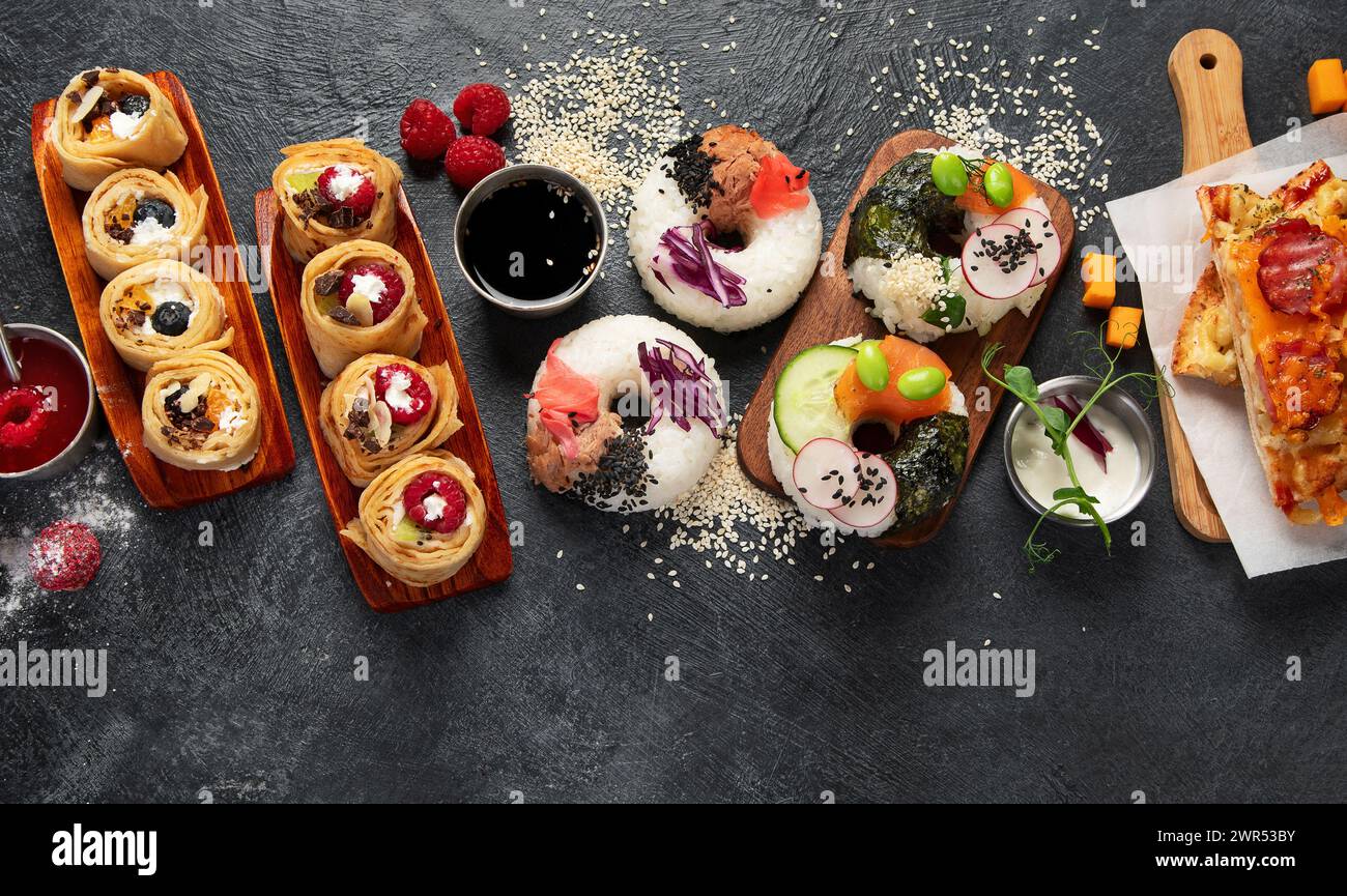 Hybrid trendy food on dark background. Sushi roll pancake, donut sushi ...