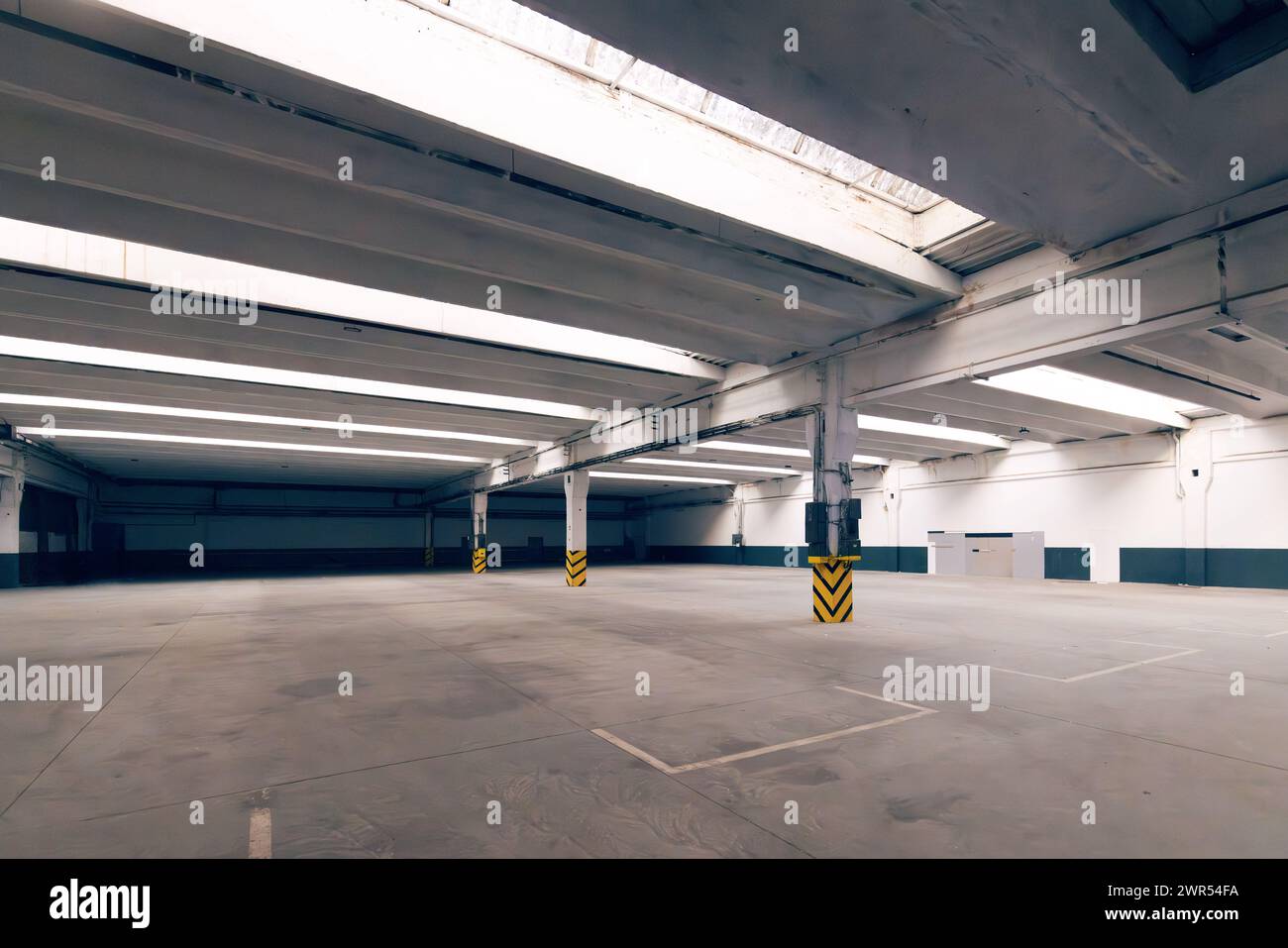Interior of spacious empty industrial warehouse or parking lot ...