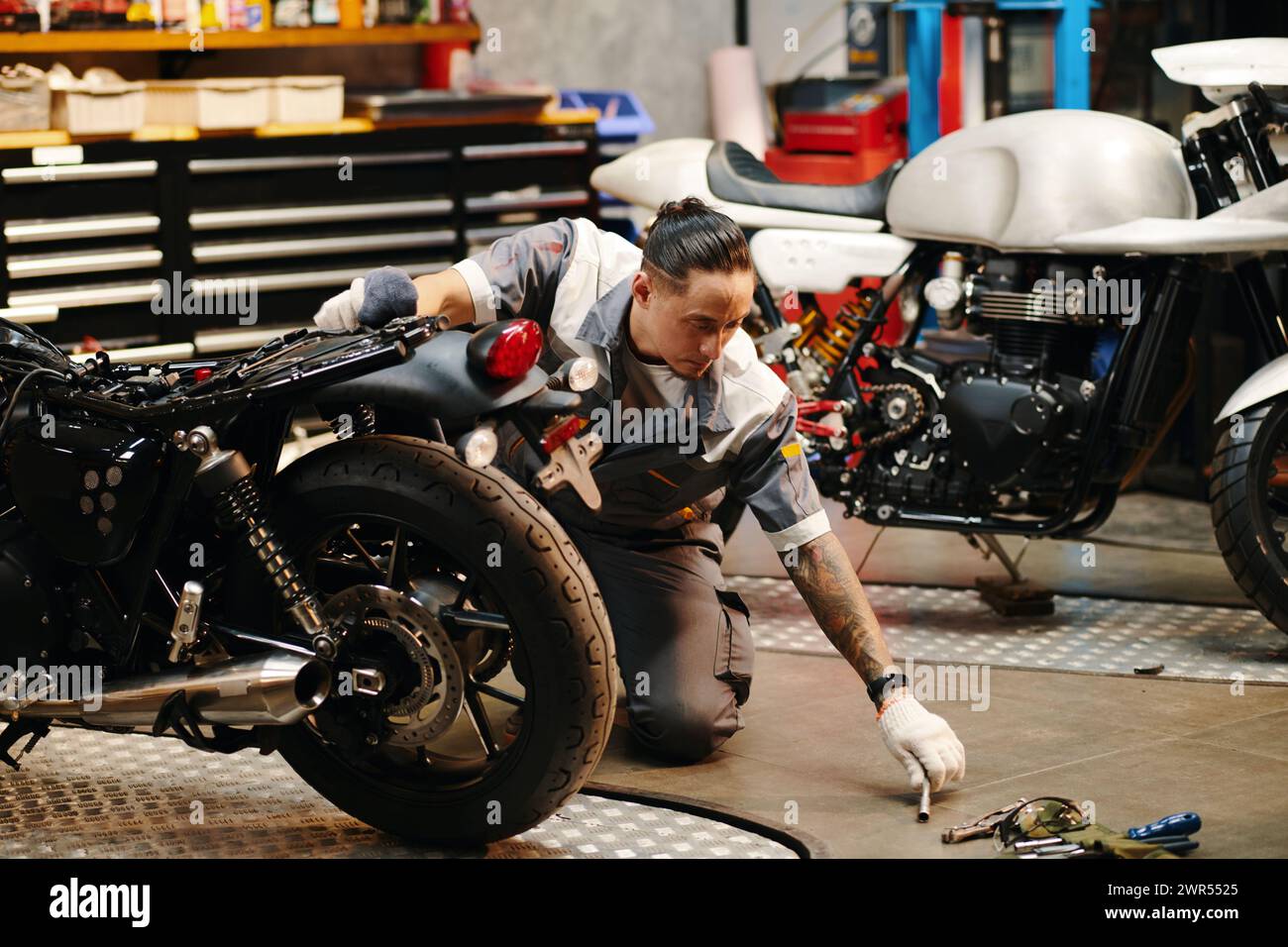Mechanic working in garage, changing parts of motorcycle Stock Photo ...