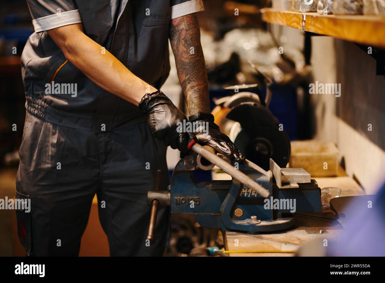 Mechanic sharpening edges of detail at repair shop workbench Stock ...