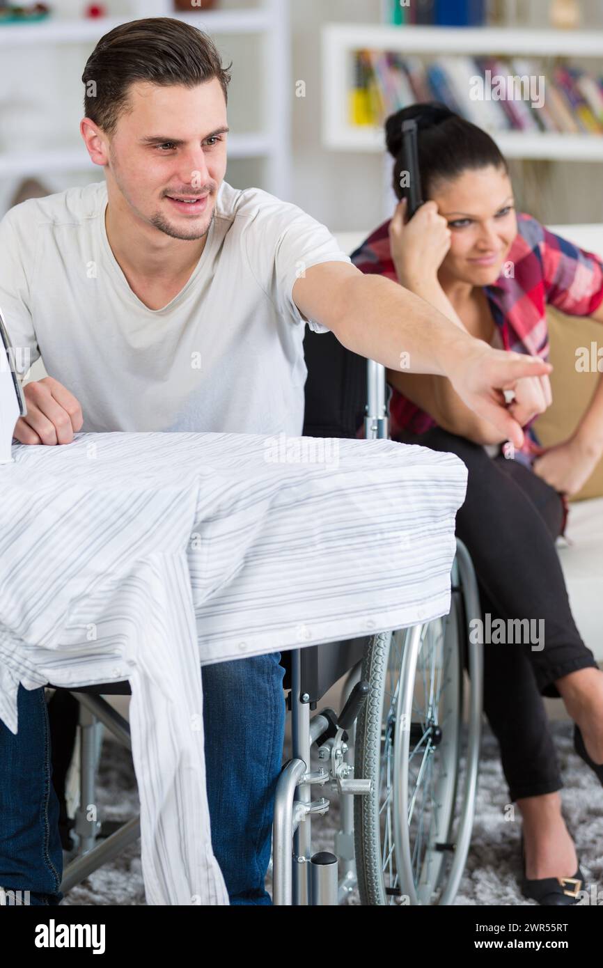 handsome handicapped man in wheelchair watching tv with his girlfriend ...