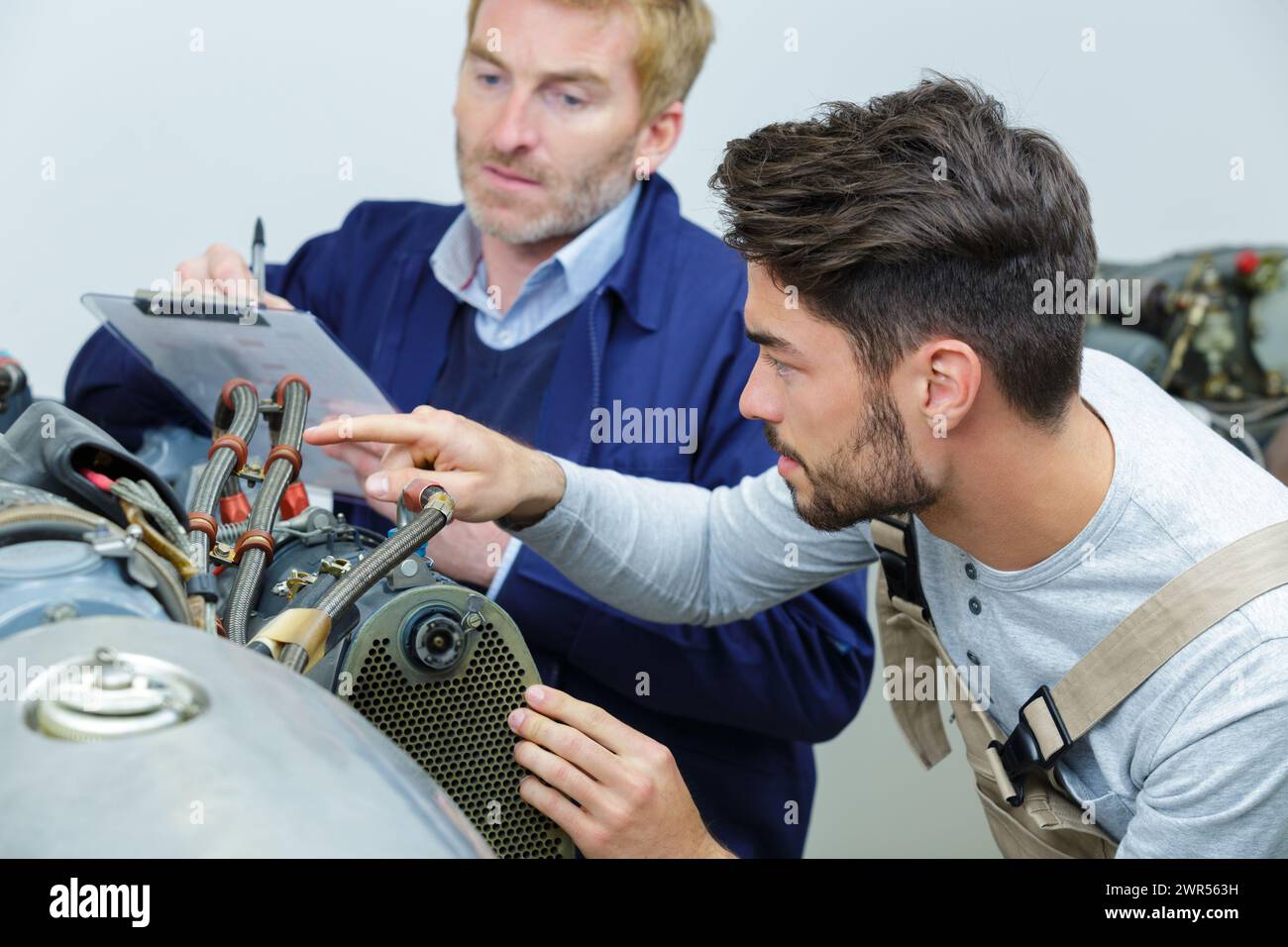 two mechanics are assembling an engine Stock Photo - Alamy