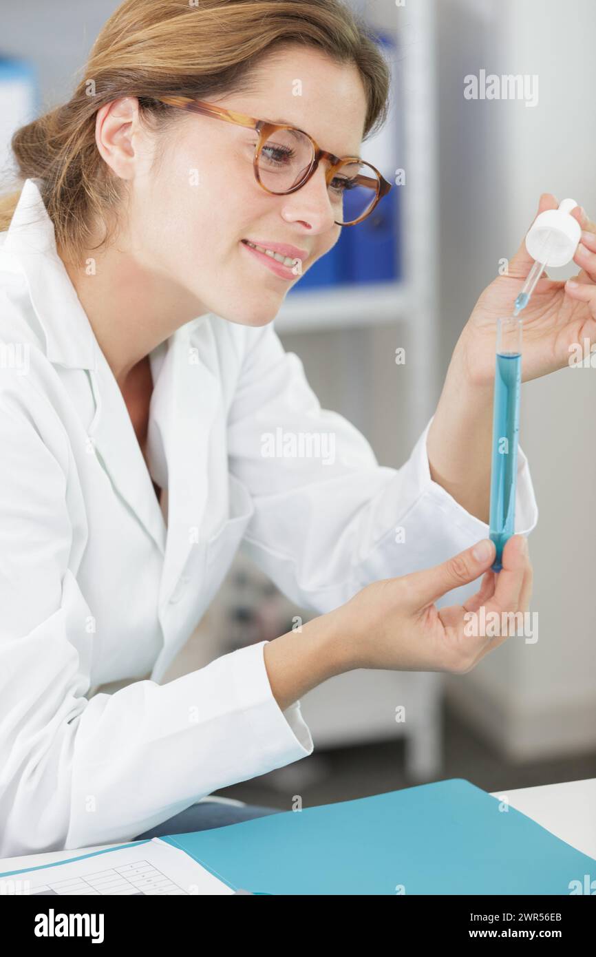 woman scientist dropping liquid substance into the test tube Stock ...