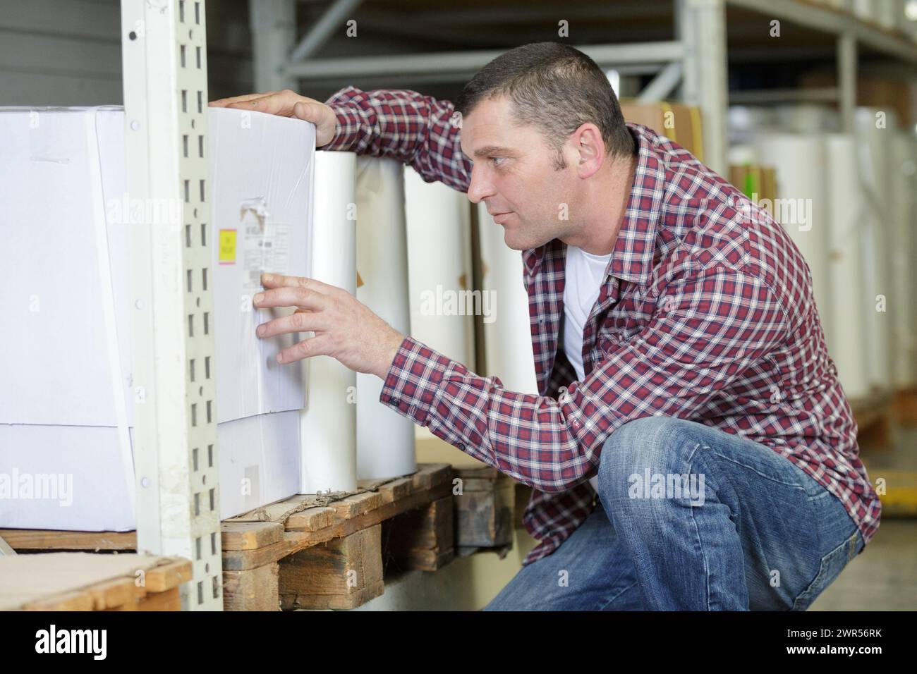 male warehouse worker checking a box Stock Photo - Alamy