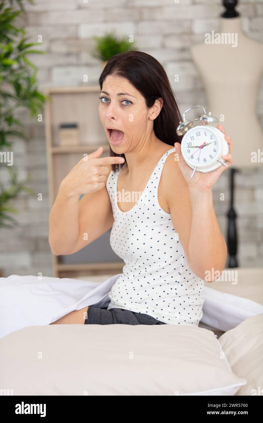 shocked young woman waking up with alarm Stock Photo - Alamy