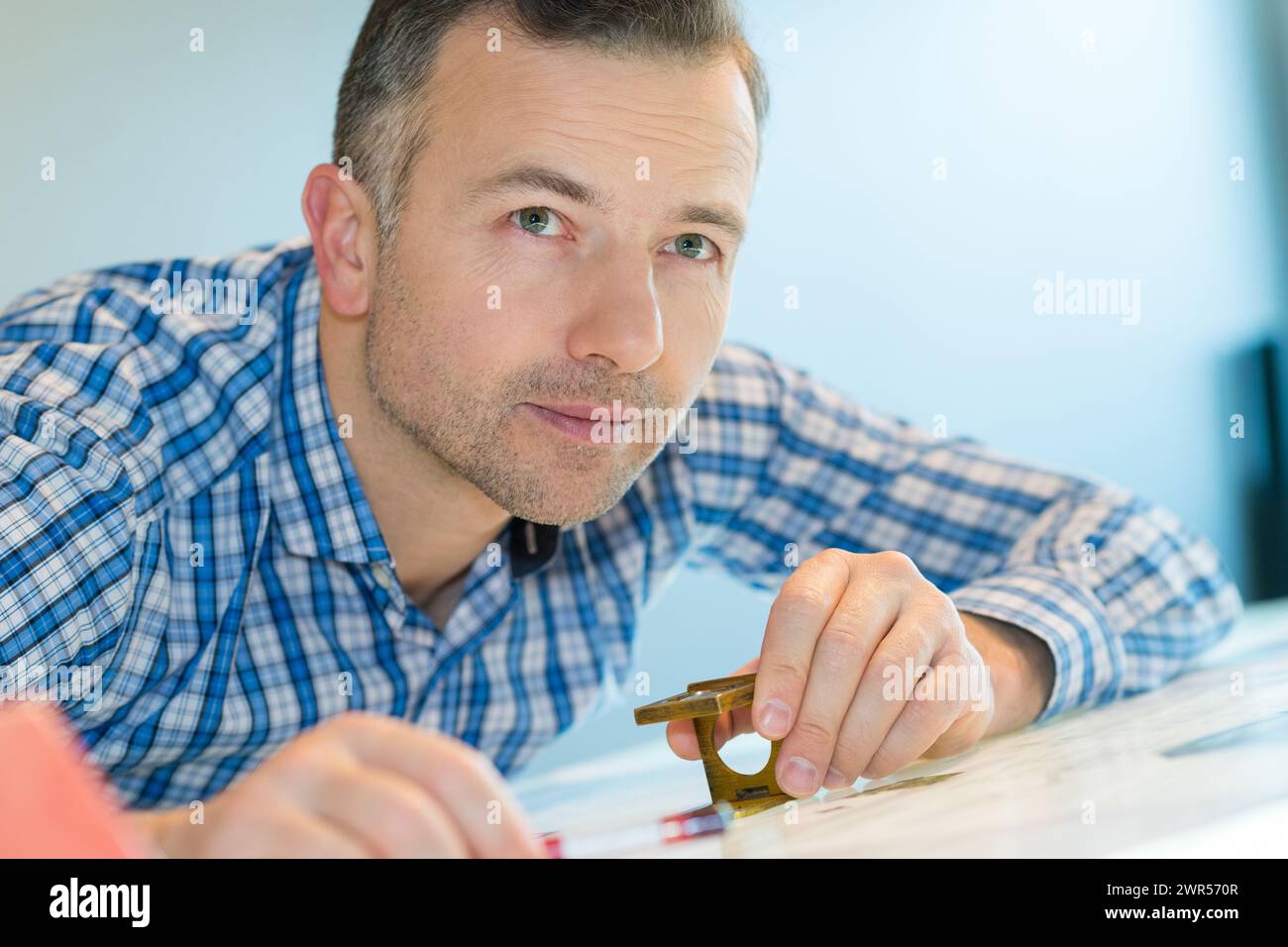 worker in a printing center uses a magnifying glass Stock Photo - Alamy