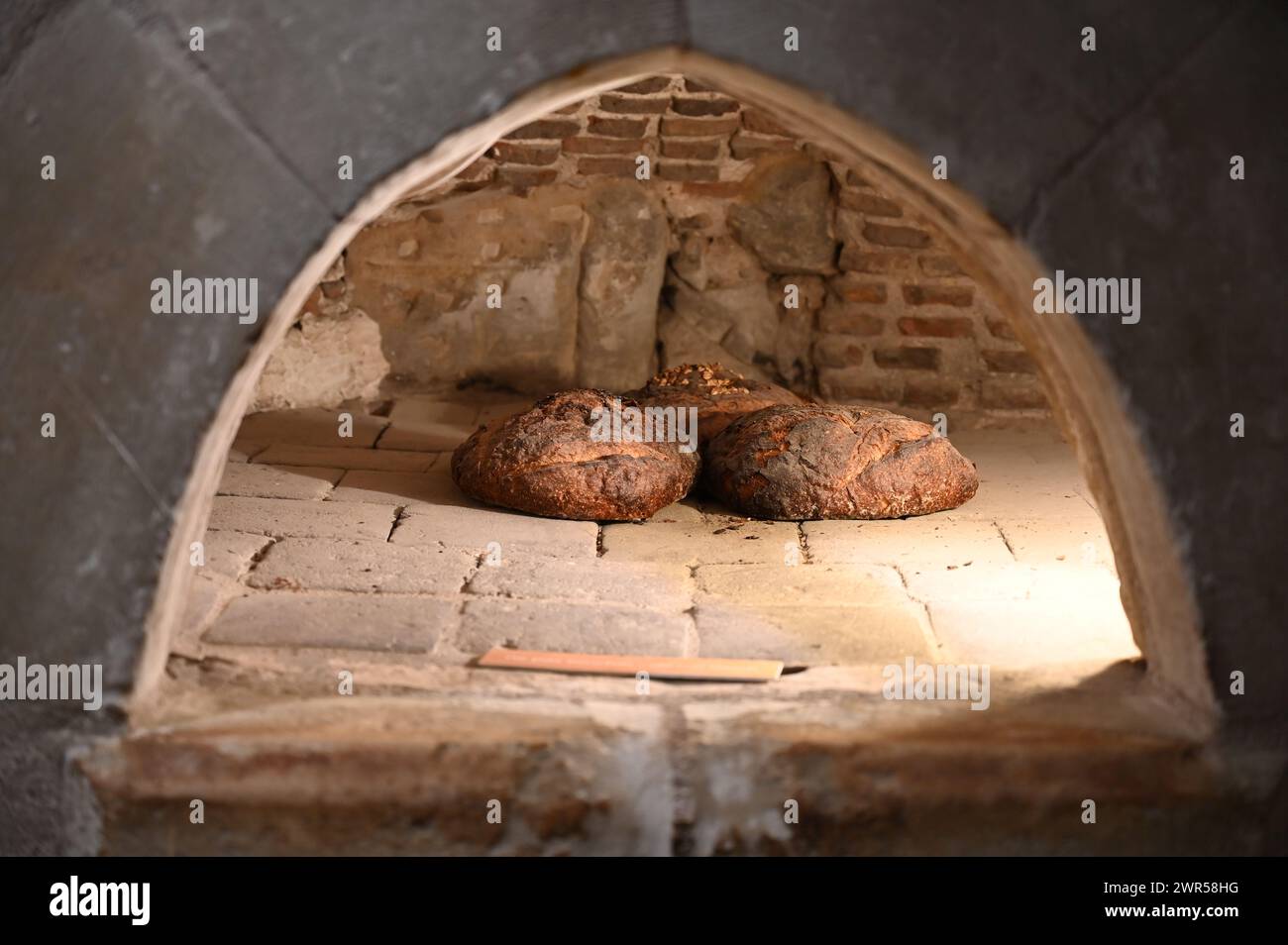 A fresh bread baking in a brick oven, ready to be served Stock Photo ...