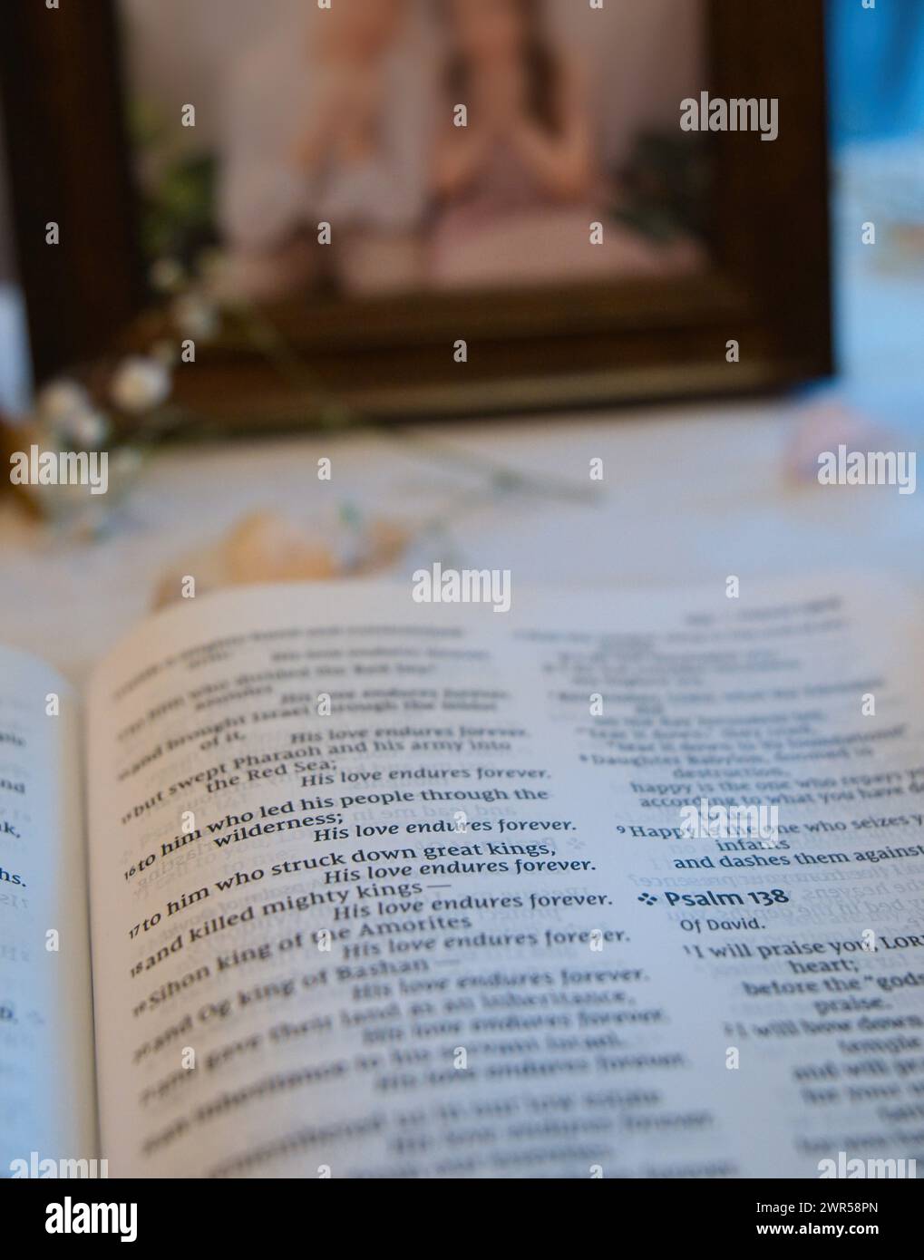 Opened bible on table showing verse on love in Book of Psalms, next to ...