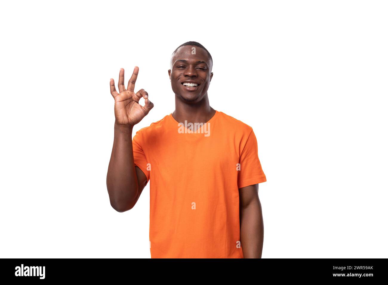 young slender American man dressed in an orange cotton t-shirt with a ...