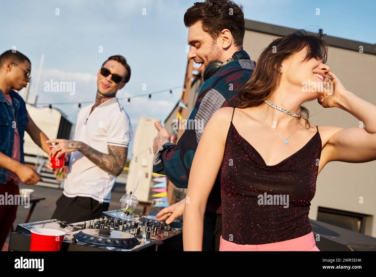 joyous long haired woman partying next to her cheerful multiracial ...