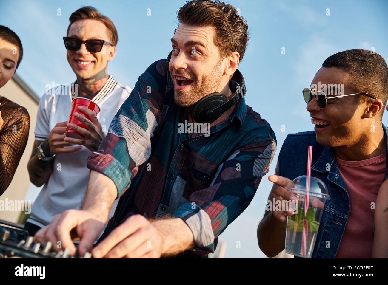 group of joyous multiracial friends drinking cocktails and partying ...