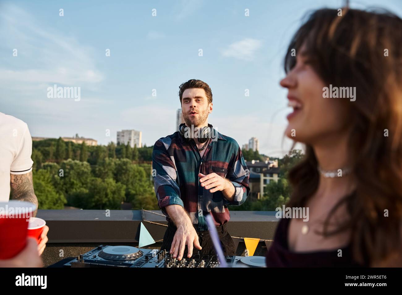 focus on handsome joyous DJ playing music for his blurred cheerful ...