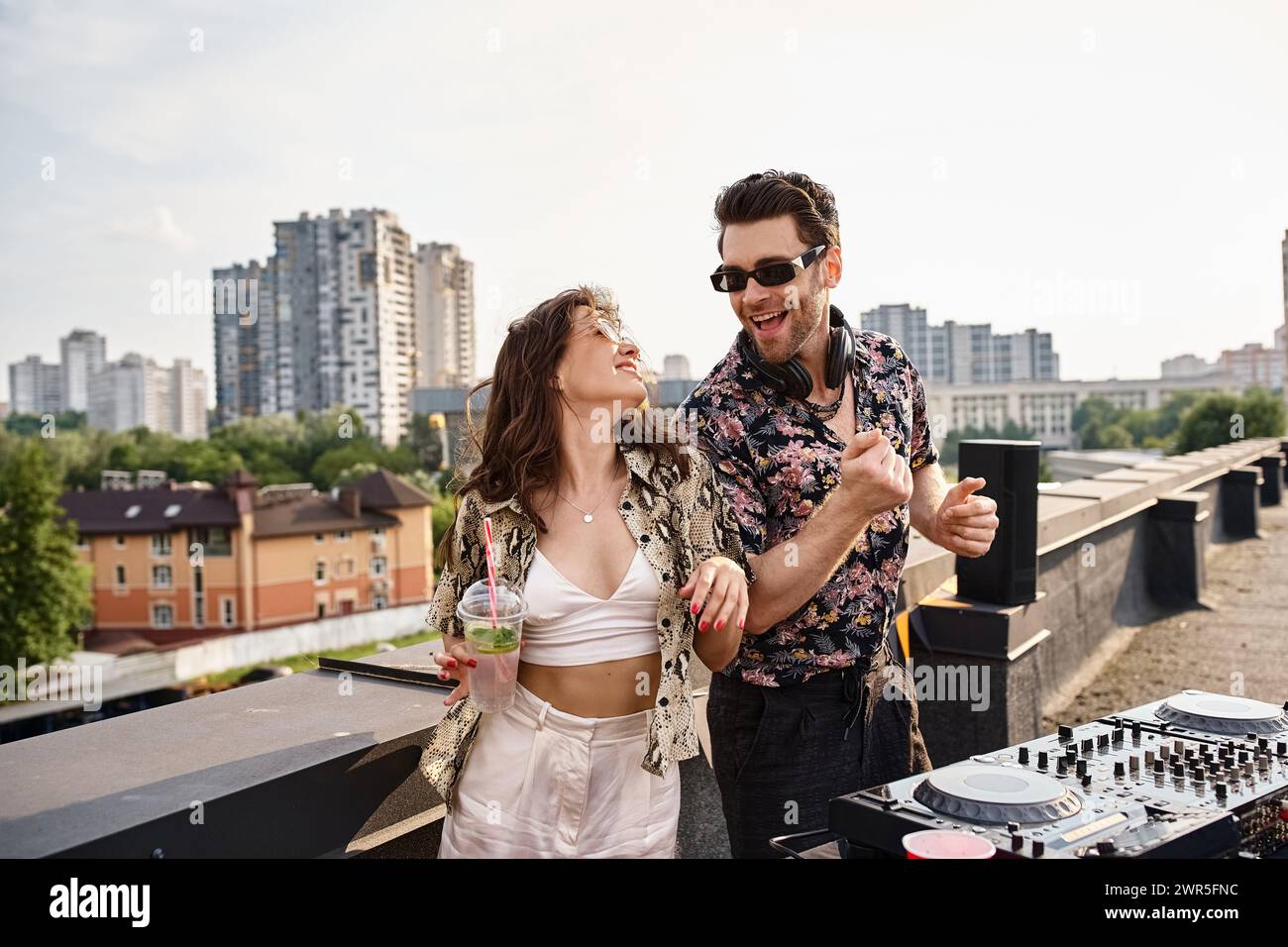 jolly beautiful woman with cocktail dancing with handsome joyous DJ to ...