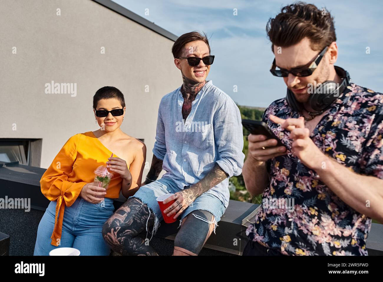 handsome DJ looking at his phone next to his jolly friends with ...