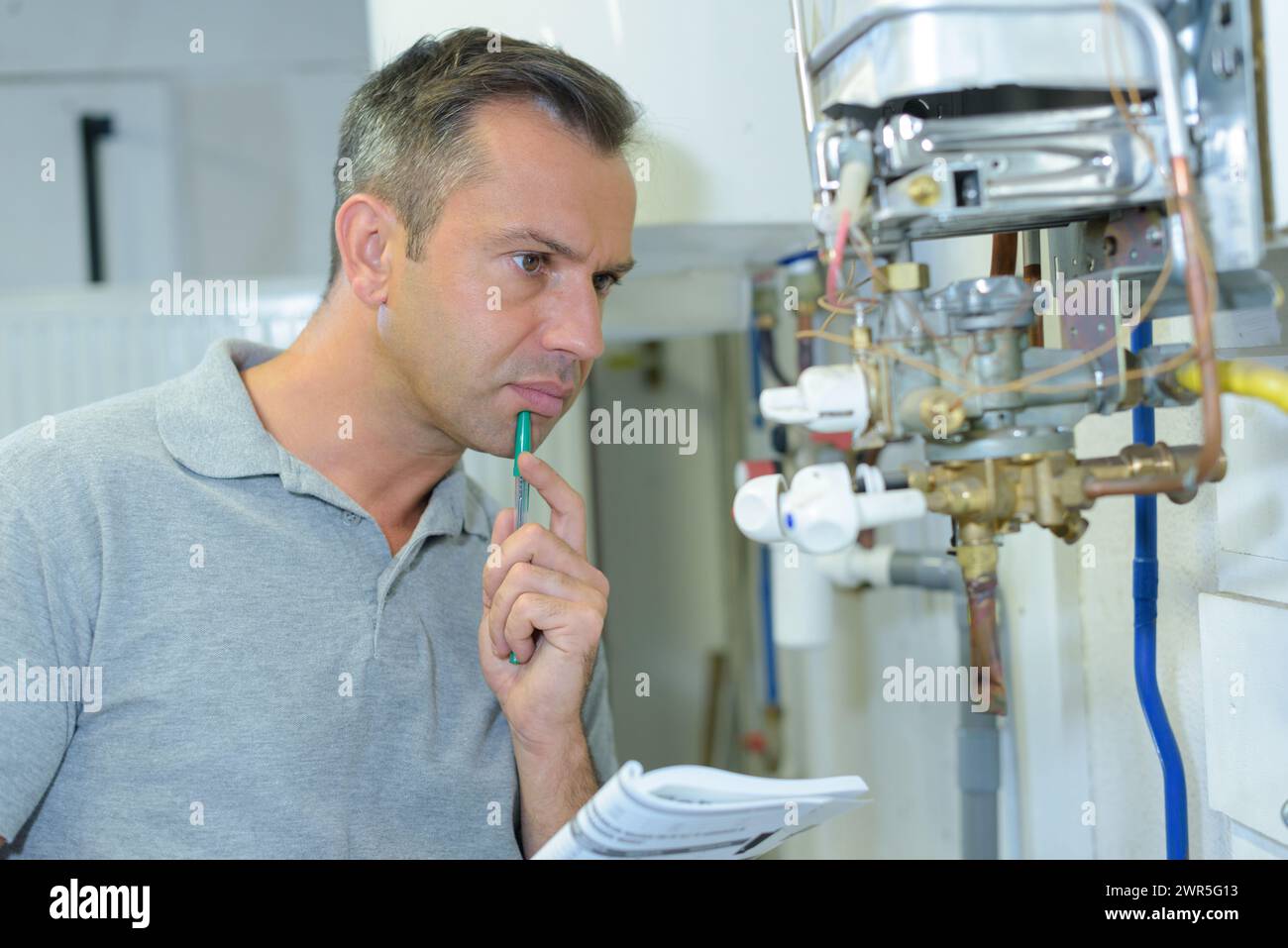 man holding instructions paper while looking at machine Stock Photo - Alamy