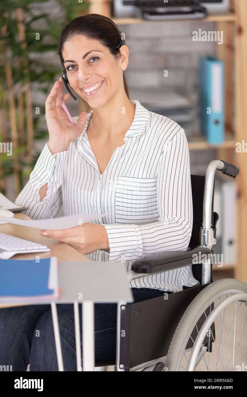 woman sitting in wheelchair working in modern office Stock Photo - Alamy