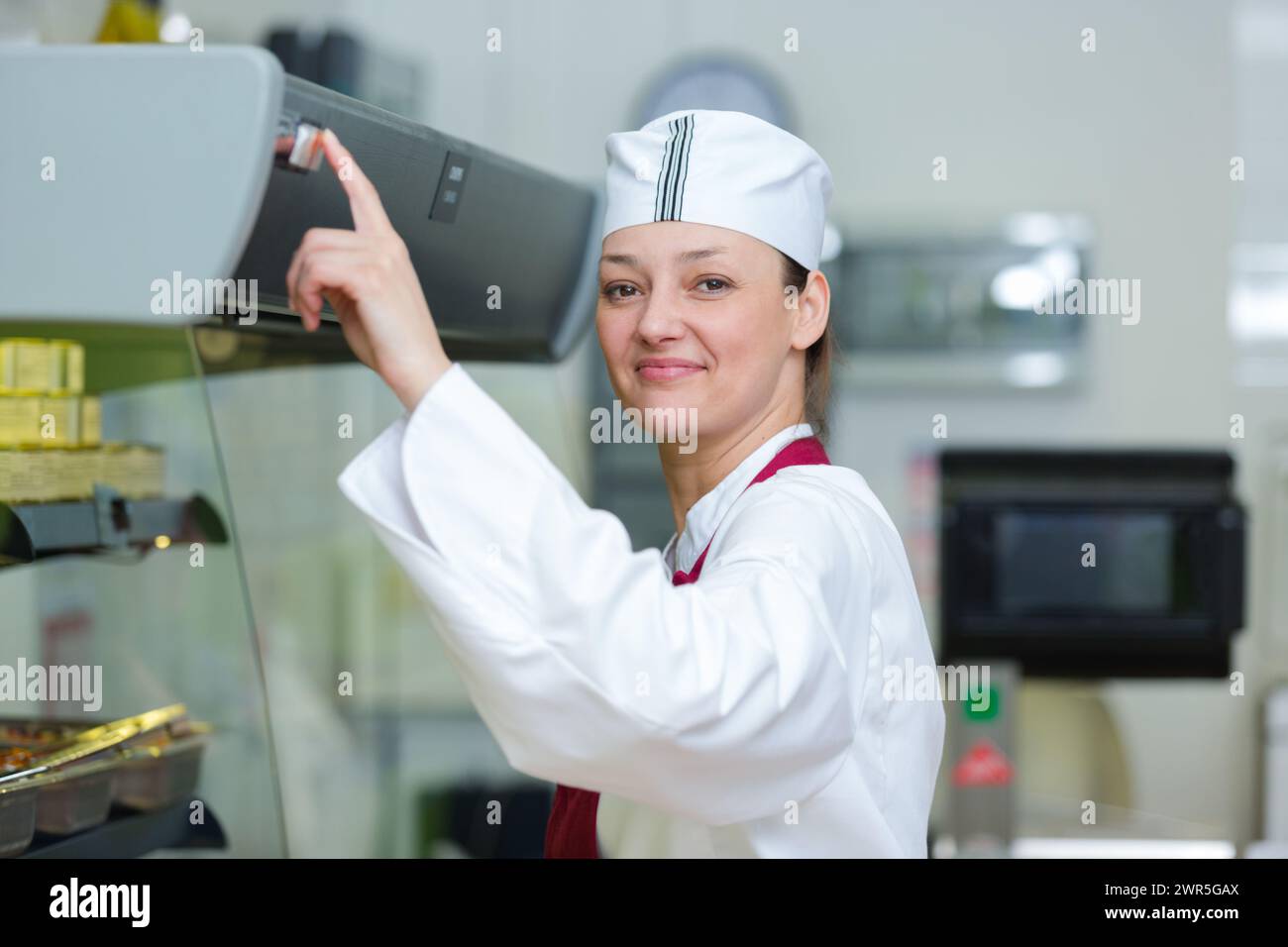 female worker with hand on chiller unit power button Stock Photo - Alamy